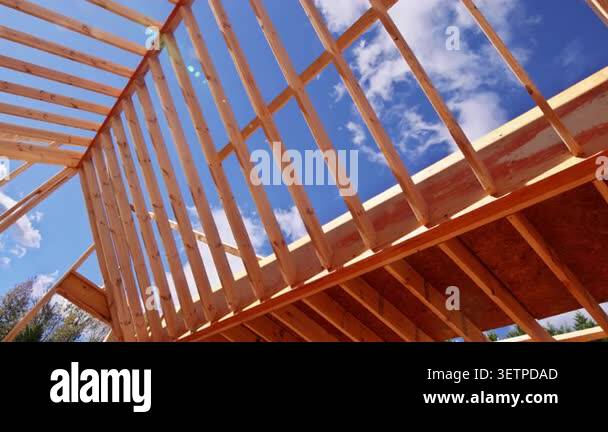 Workers are constructing wooden frame beams for new building under roof ...