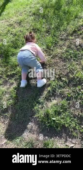 Vertical back view of a cute little girl crawling on all fours, trying ...