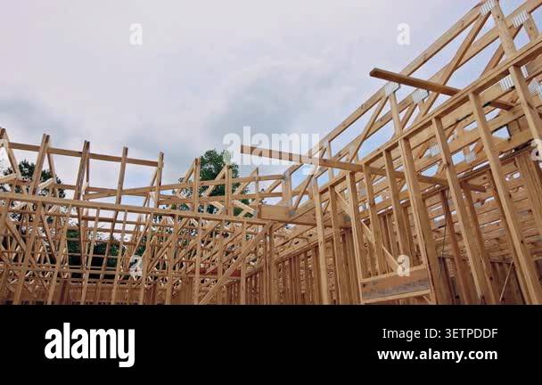 Workers are building structure with wooden roof joins framework roofing ...