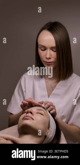 Professional female beautician finishing skincare procedure and ...