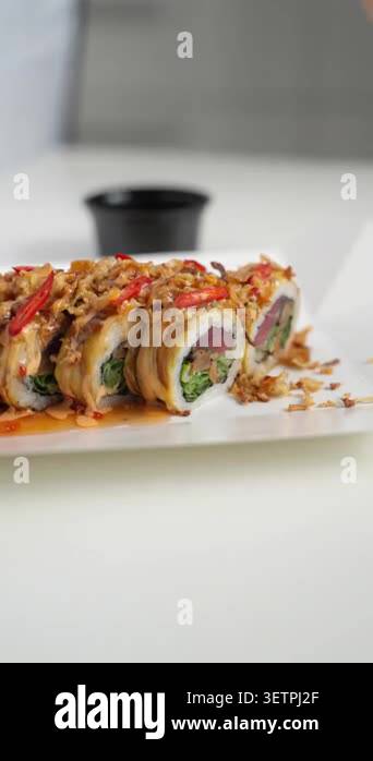 Close-up of a hand using chopsticks to pick up a delicious uramaki ...
