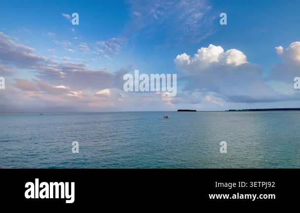 Serene Tropical Seascape with Small Boat Traveling Between Distant ...