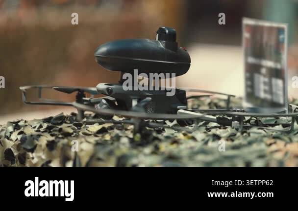 Close-up of a military surveillance quadcopter starting its propellers ...