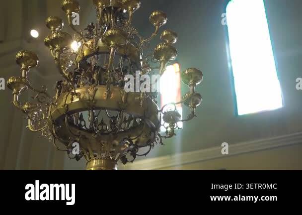 Detailed chandelier closeup with bright window glow, ornate arms and ...