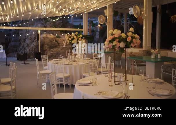 Outdoor reception under string lights with round tables, white chiavari ...