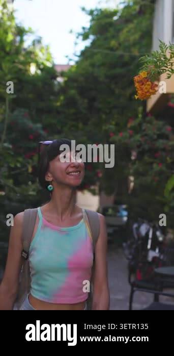 vertical video. An attractive young tourist explores a new city. A girl ...