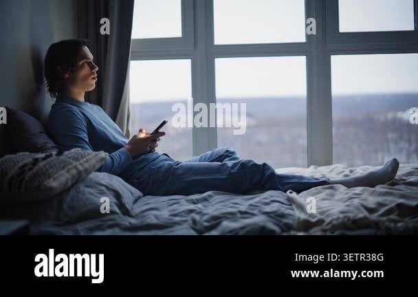 Evening man watching cellphone social media sitting soft pillows at ...
