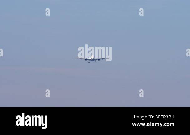 Passenger airplane flying on final approach with landing gear extended ...