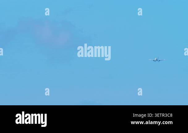 Passenger jet airplane descending for landing in clear blue sky ...