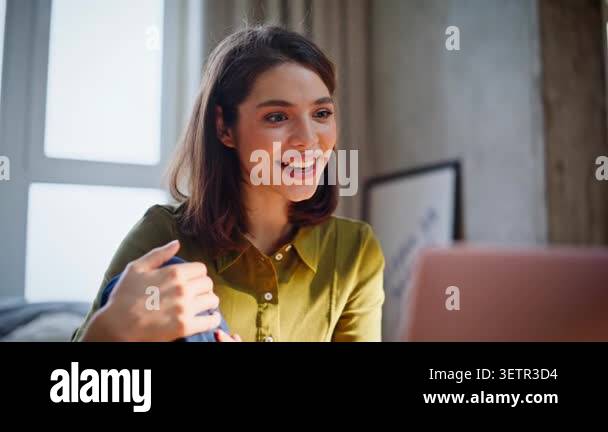 Emotional girl greeting video meeting in cozy bedroom interior portrait ...