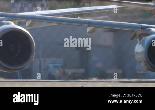 Jet engine and airplane wing taxiing on airport tarmac with heat haze ...