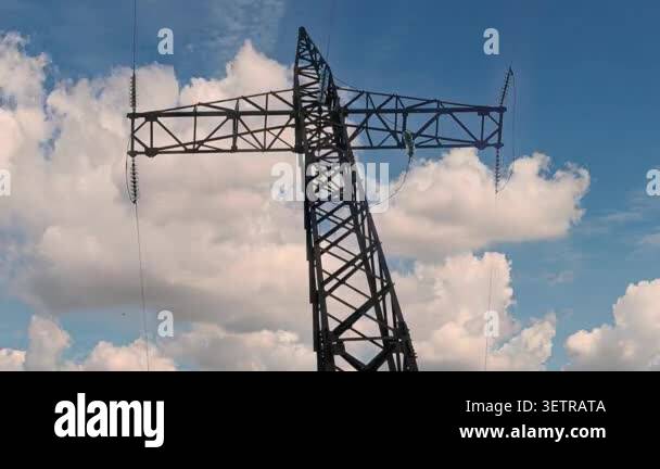Timelapse shot of a high voltage power line tower silhouetted against a ...