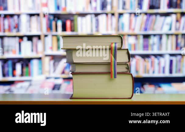 Books.Table and person hands picking up with rainbow flag books at ...