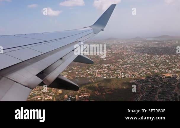 Beautiful view of airplane wing over coastal city and bay seen from ...