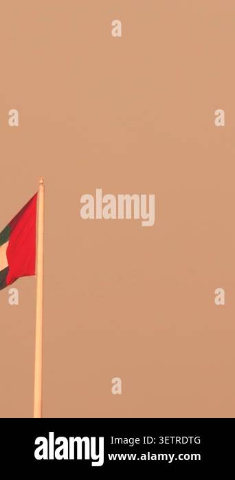 United Arab Emirates flag waving against warm golden sky at sunset ...