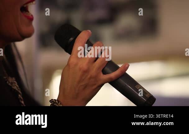 Expressive hands holding microphone during Romani music performance ...