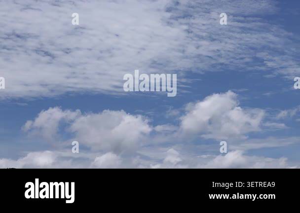Blue sky with layered white clouds drifting across the atmosphere ...