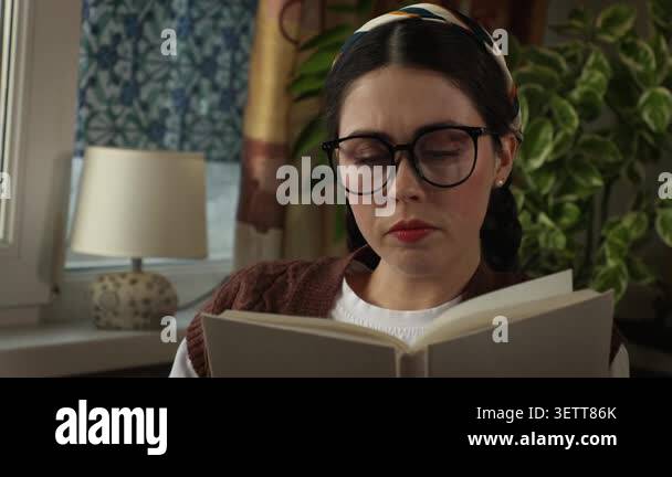 Portrait of Caucasian female showing dissatisfaction with a book while ...
