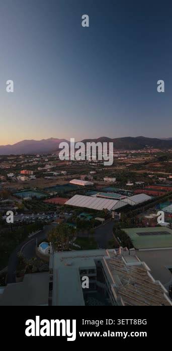 Vertical drone video flying over a coastal valley with sports tennis ...