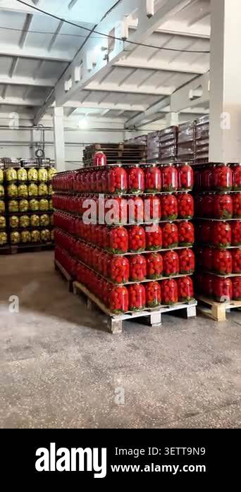 Four frames show a warehouse filled with stacks of colorful cans. The ...