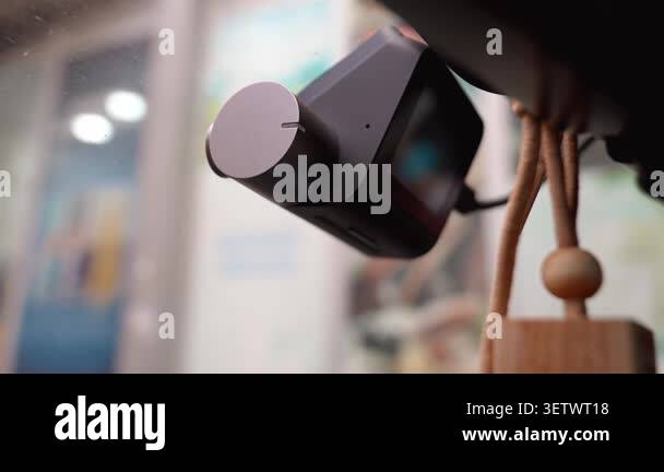 Modern car dashcam with a wooden air freshener is mounted on the ...