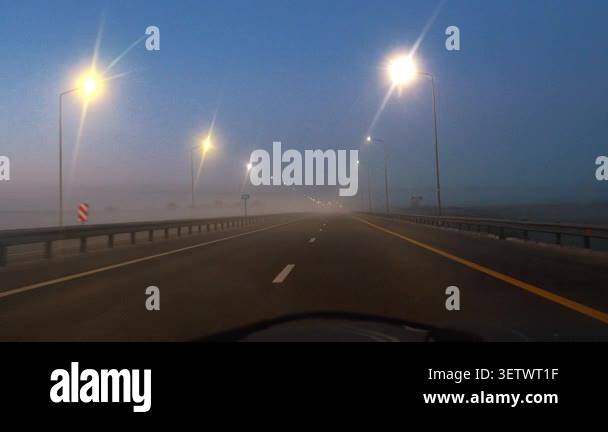 Point of view shot driving along an empty highway shrouded in thick fog ...