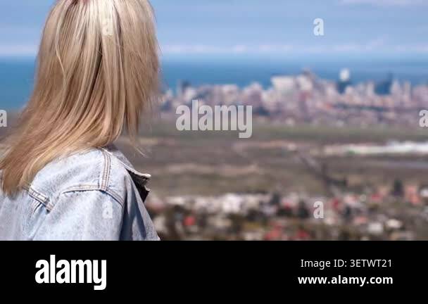 Blonde woman wearing a denim jacket enjoying the beautiful panoramic ...