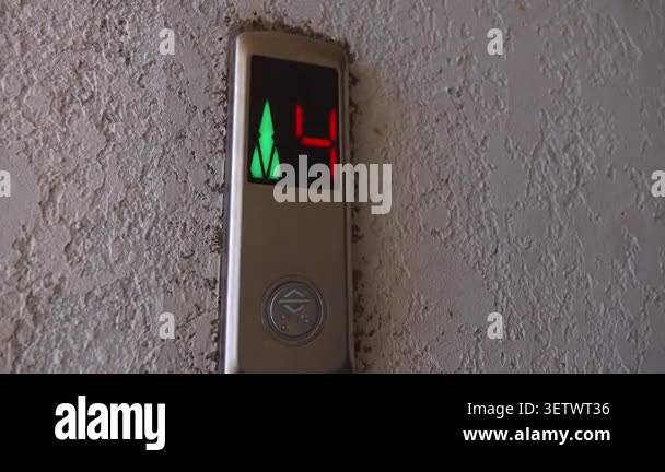 Modern elevator floor indicator with red digital numbers and a green ...