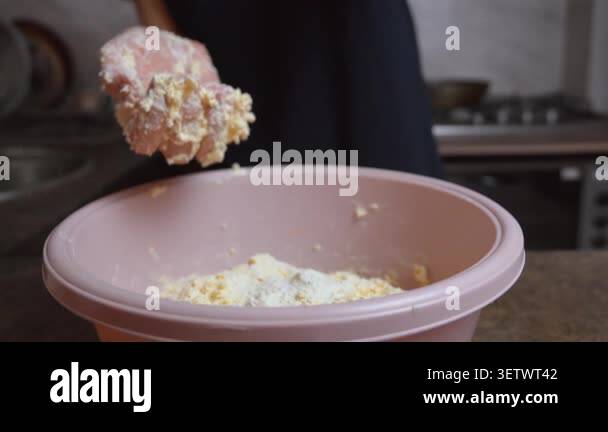 Female hands adding a spoonful of flour into a pink bowl and then ...