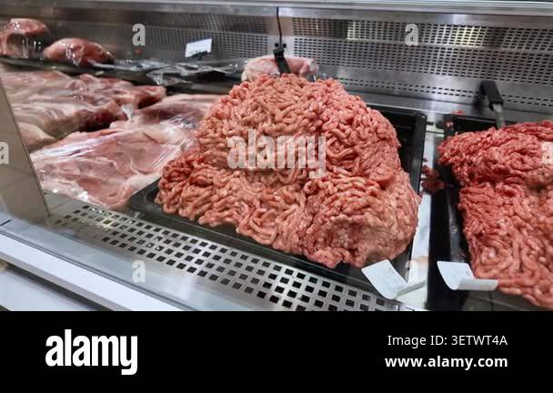 Raw minced meat on a tray inside a refrigerated display case in a ...
