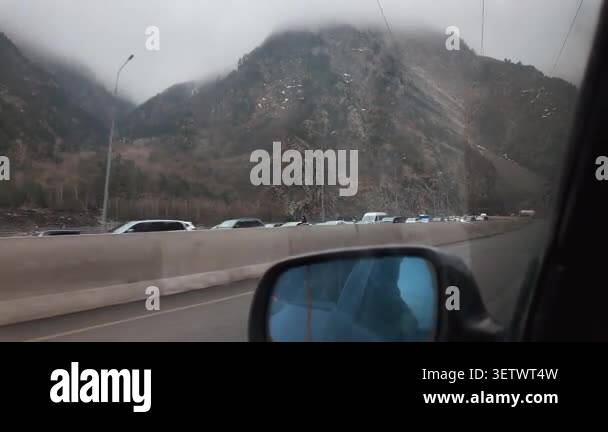 Point of view from a car window driving on a highway alongside a long ...