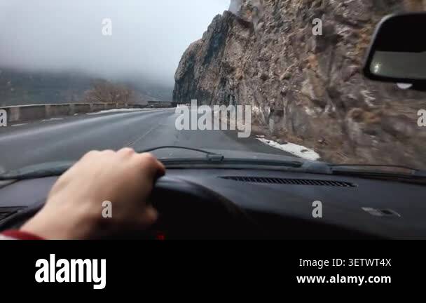 First-person view from a car driving along a narrow, winding asphalt ...
