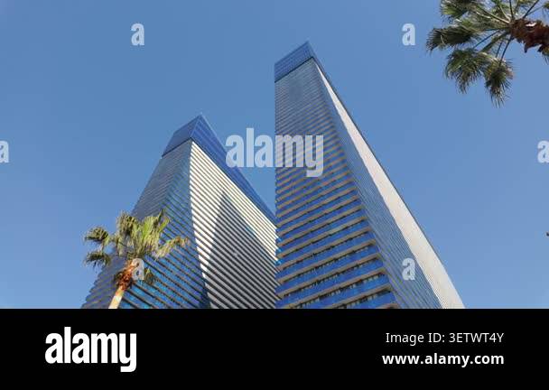 Low-angle view of two contemporary glass skyscrapers with distinctive ...