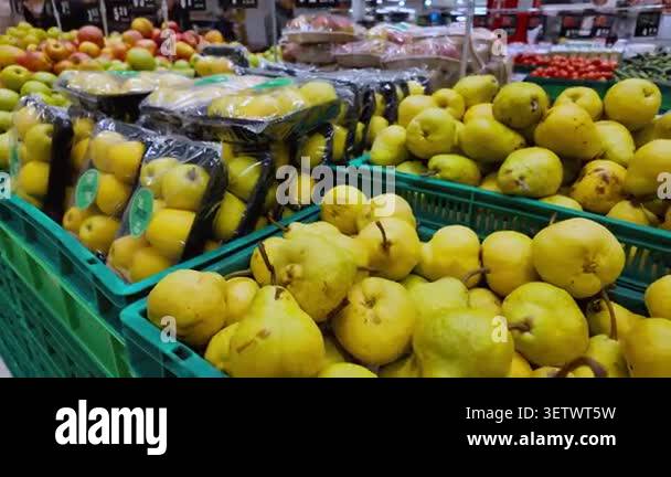 Large assortment of colorful fresh apples and pears displayed in green ...
