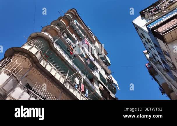 Low-angle view of weathered residential buildings with laundry hanging ...