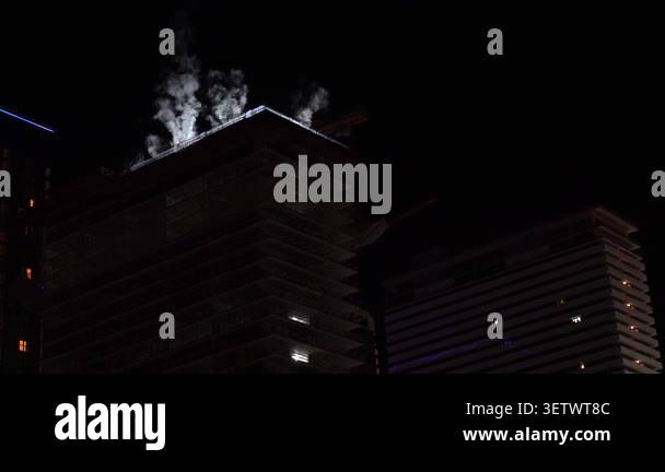 Luminous white smoke or steam rising from vents on the rooftop of a ...