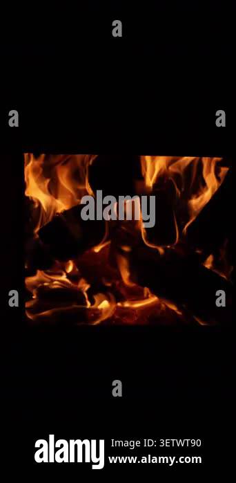 Close-up view of a warm and cozy fire burning in a fireplace, with ...