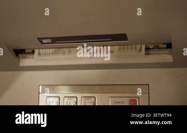 Closeup of an automated teller machine dispensing a stack of one ...