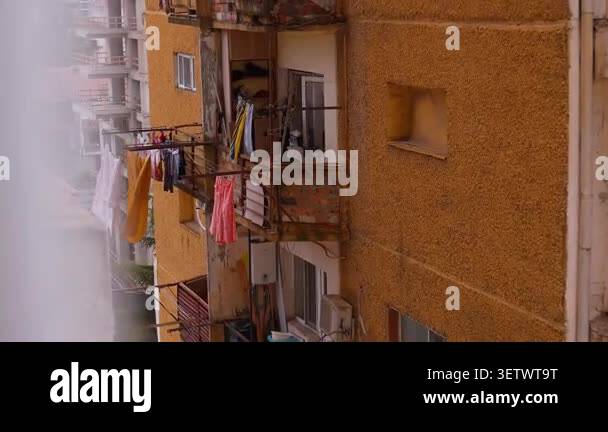 Old residential apartment building with laundry drying on weathered ...