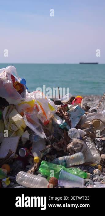 Large pile of plastic waste and garbage polluting a pebble beach, with ...