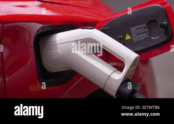 Close-up view of a modern electric vehicle plugged into a charging ...