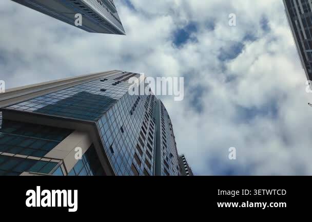 Upward rotating view of modern glass skyscrapers reaching towards a ...
