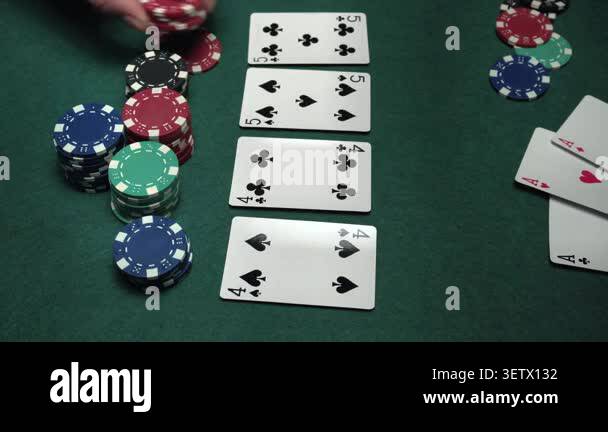 Hand moves red poker chips to stack on playing cards displaying pairs ...