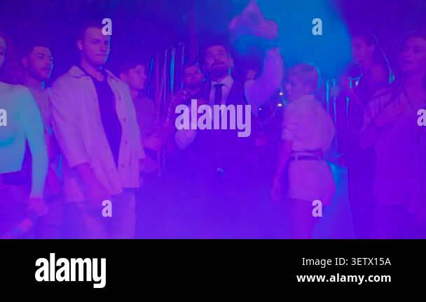 A lively club scene shows diverse partygoers dancing under captivating ...