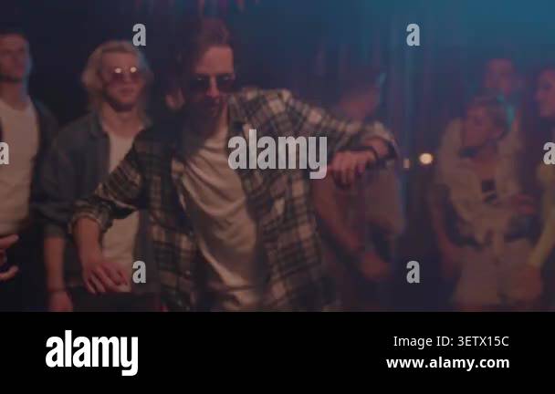 A lively party atmosphere unfolds as a man in stylish sunglasses ...