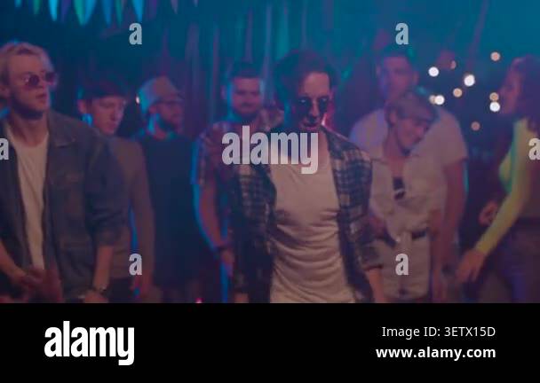 Energetic nightlife thrives as young people dance joyfully in a club. A ...