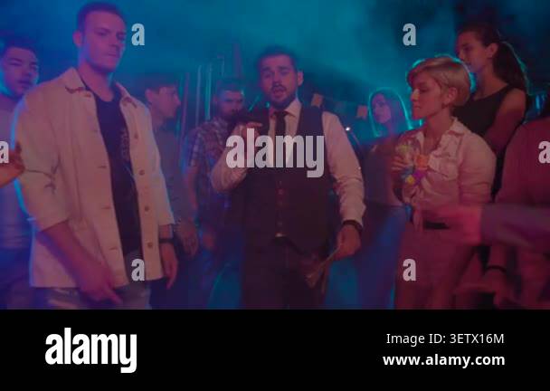 This upbeat video captures a vibrant party with a welldressed man in a ...