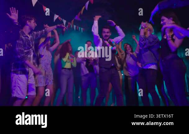 The video showcases a lively party with people dancing in a dim room. A ...
