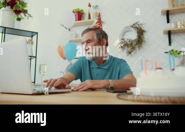 An elderly man is happily enjoying a virtual birthday celebration while ...