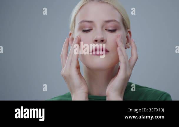 A woman gently applying an array of skincare products for achieving a ...